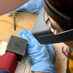 Conservators painstakingly remove glue that binds