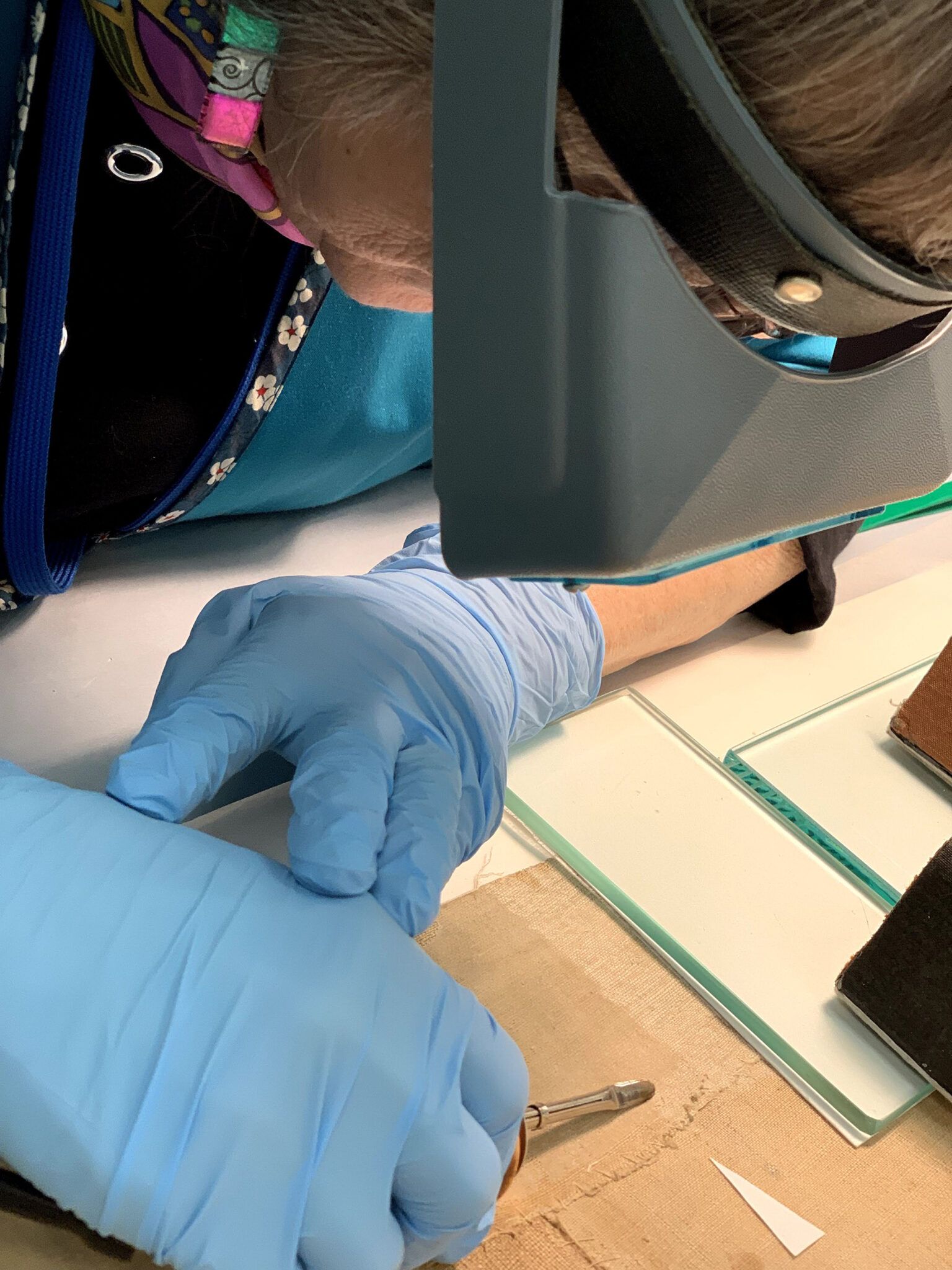 Conservators painstakingly remove glue that binds